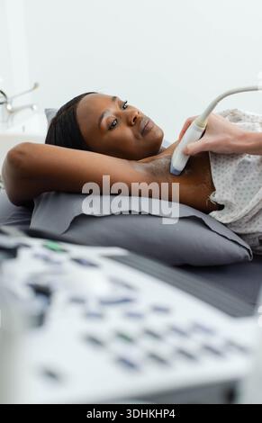 Hand holding ultrasound probe on pregnant belly with fetus image on ...