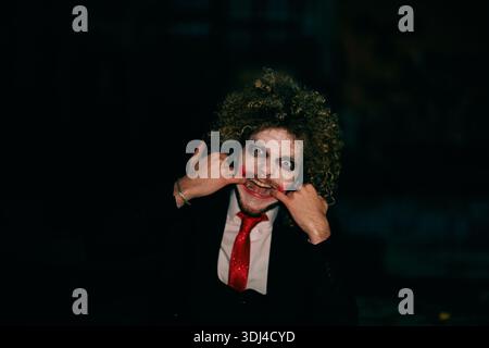 Creepy Clown Man in Vest and Red Tie Gesturing at Night Outdoors Stock ...