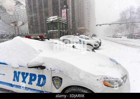 Row of police cars covered in snow during Sunday's blizzard near ...