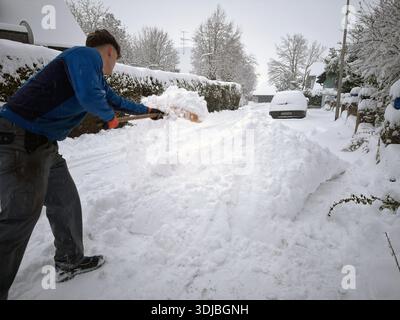 Forchheim, Germany. 26th Jan, 2026. A man shovels snow from a sidewalk ...