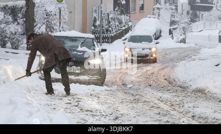 Forchheim, Germany. 26th Jan, 2026. A man shovels snow from a sidewalk ...