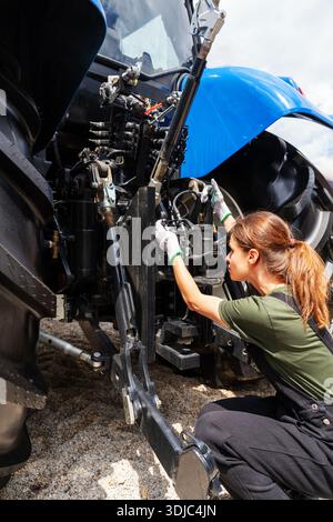 Woman repairing tractor Stock Photo - Alamy