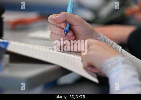 15 January 2026, Rhineland-Palatinate, Mainz: A pupil holds a pen and ...