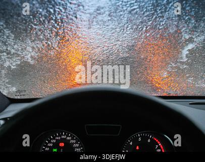 26 January 2026, Berlin: The iced windshield of a car before it is ...