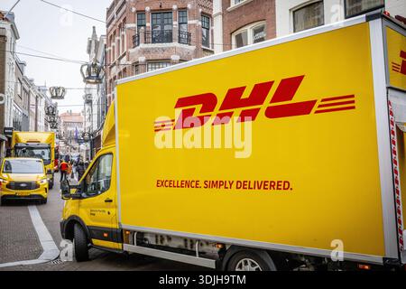 THE HAGUE - Delivering a DHL package with a truck in the city center ...