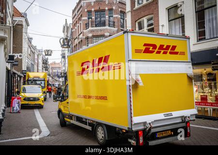 THE HAGUE - Delivering a DHL package with a truck in the city center ...