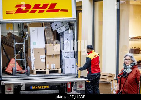 THE HAGUE - Delivering a DHL package with a truck in the city center ...