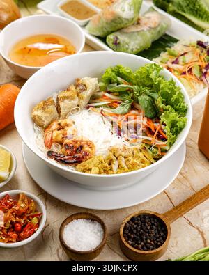 Vibrant seafood noodle bowl featuring shrimp squid carrots greens in ...