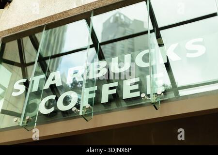 Starbucks logo is seen as people walk in front of the shop on landmark ...