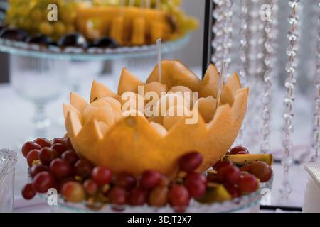 Vibrant yellow melon slices arranged on a white ceramic plate with a ...