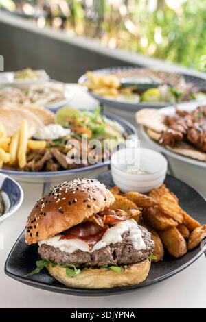 Gourmet wagyu beef burger wirh bacon, cheese and wedge fries on outdoor ...