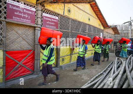 Rohingya volunteers work together to repair their shelter inside a ...