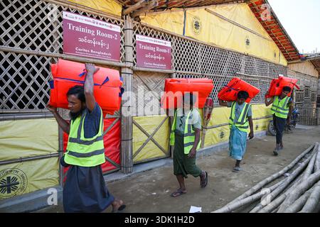 Rohingya volunteers work together to repair their shelter inside a ...