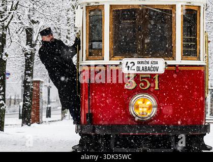 A conductor leans out of the historic tram line No. 42 at the stop ...