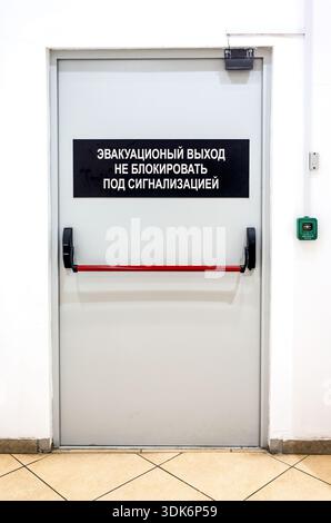 Emergency exit at city mall. Text in russian: Evacuation exit, do not ...