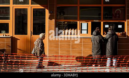 Locals purchasing fresh bread at a traditional street bakery window on ...