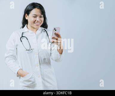 Asian female doctor using smartphone at medical office desk with ...
