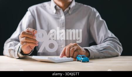 Person calculating vehicle expenses with a calculator while reviewing ...
