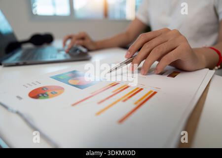 Man analyzing financial charts and tax documents at home desk for ...