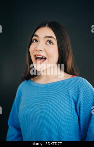 Beautiful young woman feeling very excited and raising her arms ...
