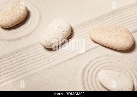 Composition with spa stones and lines on sand as background, closeup ...