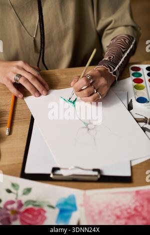 A young woman expresses her creativity by painting a vibrant picture at ...