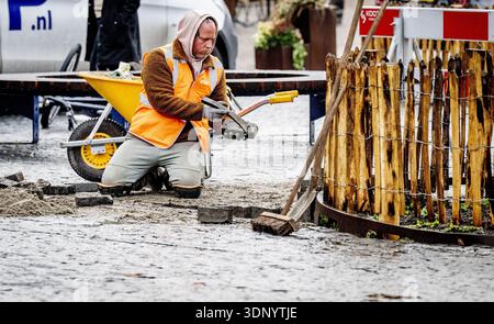 UTRECHT - A road paver performs heavy work on his knees during his work ...