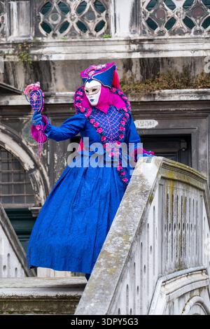Photogenic masked woman in ornate costume poses for the camera during ...