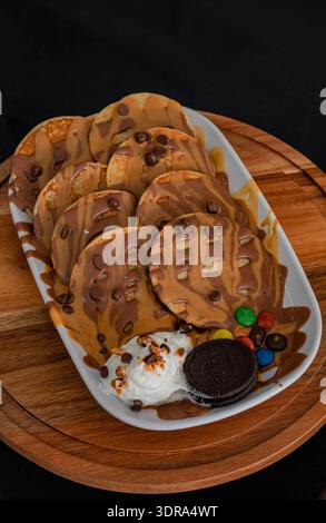 Rich hazelnut chocolate spread in white bowl. Hazelnuts, cinnamon stick ...