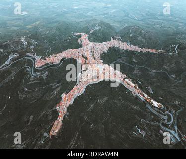 Aerial view of a winding, S shaped road through a sandy, dry landscape ...
