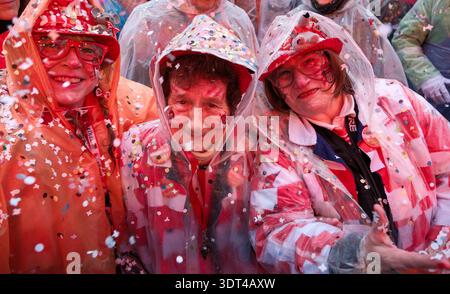 Carnival revellers wearing transparent rain ponchos and covered in ...