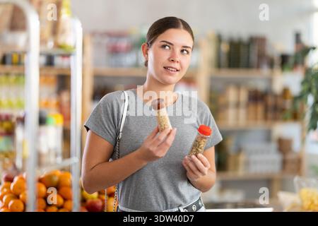 Young woman choosing seasoning herbs in grocery Stock Photo - Alamy