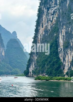 Karst limestone mountains along river with lush vegetation in Ninh Binh ...