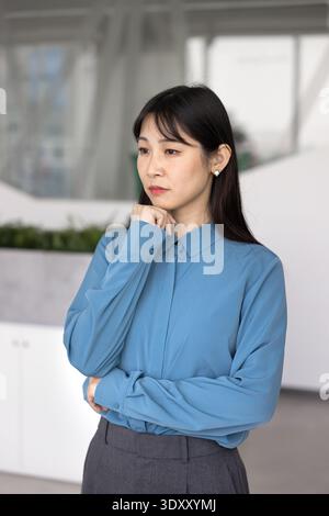 Young Asian woman professional thinking contemplating while writing ...