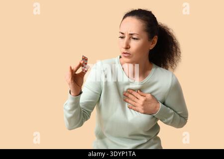 Mature woman with pills having heart attack on white background Stock ...