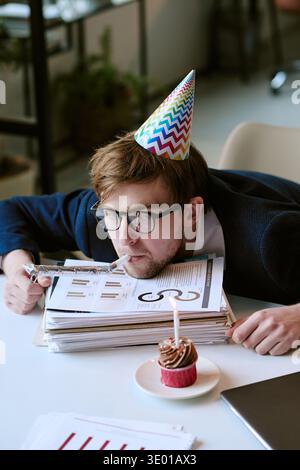 Young man in party hat with gift box celebrating Birthday and showing ...