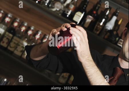 a barkeeper or bartender mixing drinks together in a bar barkeeper ...