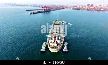 A cargo ship loaded with imported iron ore sails to Qingdao Port via ...