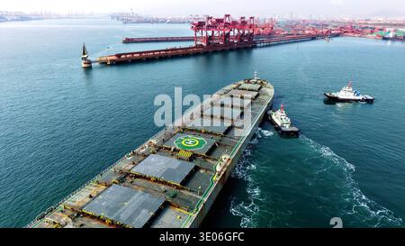 A cargo ship loaded with imported iron ore sails to Qingdao Port via ...