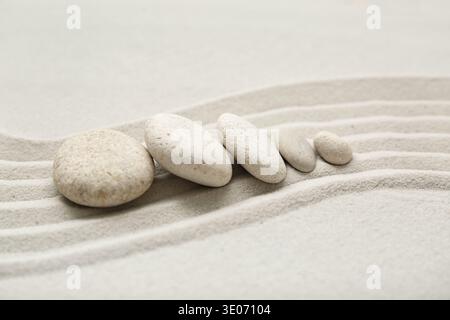 Composition with spa stones and lines on sand as background, closeup ...
