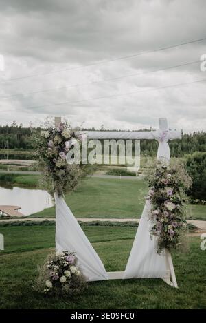 Outdoor wedding ceremony setup with white chairs and floral aisle Stock ...