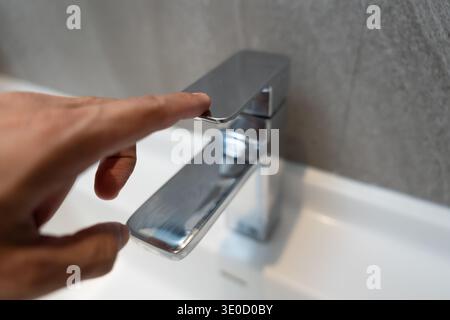 Save water. Man keeps turning off the running water in the bathroom to ...
