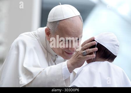 Pope Leo XIV greets a child as he arrives for his weekly general ...
