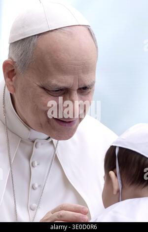 Pope Leo XIV greets a child as he arrives for his weekly general ...