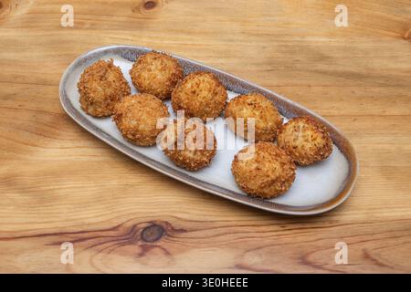 Croquettes cut in half to show the filling: some with thick béchamel ...
