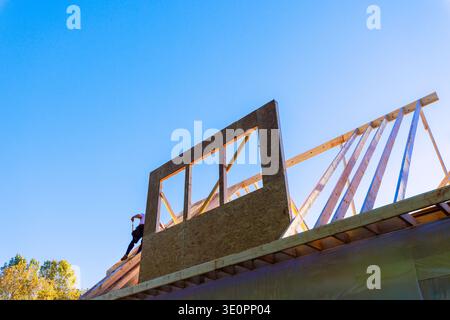 Contractor installs wooden beams trusses in forest area while wearing ...