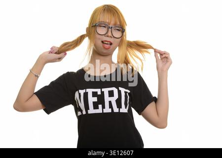 Happy smiling Asian woman playing with small black white cat on wooden ...