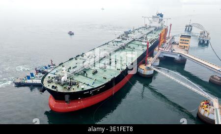 An oil tanker carrying imported crude oil docks at a berth in Qingdao ...