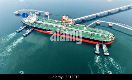 An oil tanker carrying imported crude oil docks at a berth in Qingdao ...
