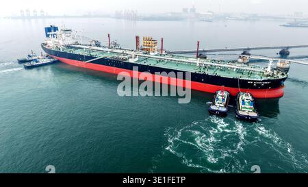 An oil tanker carrying imported crude oil docks at a berth in Qingdao ...